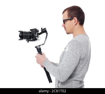 A side view of a cameraman shooting a young handsome guy looking at the ...