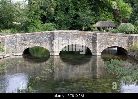 Cotswolds village of Bibury Arched Bridge over the River Coln in Bibury ...