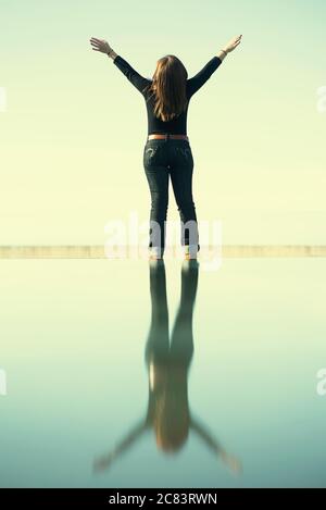 Nude woman standing with arms back, full length, side view Stock Photo ...