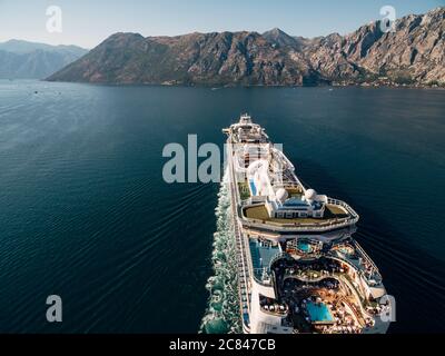 Vacationers in large swimming pool and others lounging on chairs near ...