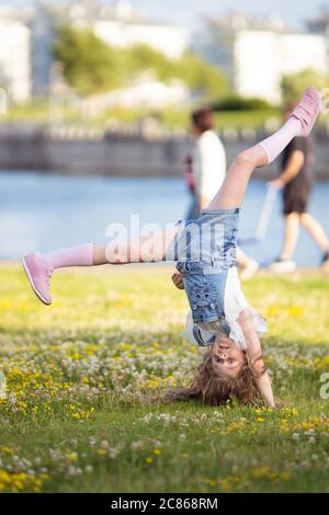 Blonde girl dancing, jumping, doing acrobatics and posing, in the city ...