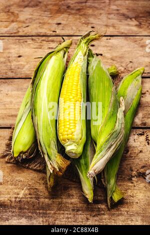 Raw corn cobs on sack set, on black background, top view flat lay Stock ...
