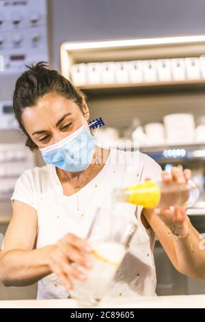 A shallow focus shot of a medical face mask hanging on a twig tree with ...