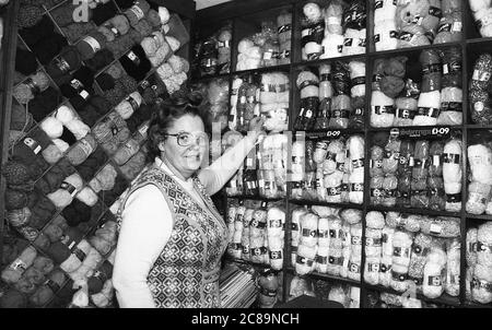 1980s, historical, female owner of a shop selling wool standing in her ...