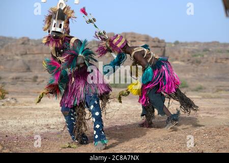 A group of Dogon men performing a ritual tribal masked dance ceremony ...