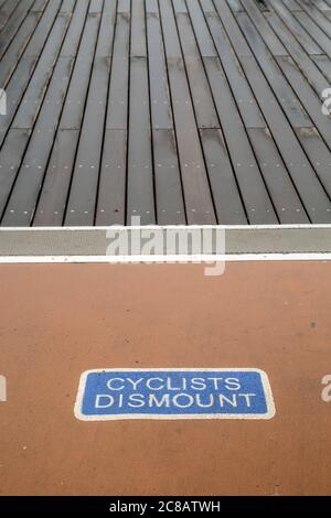 Cyclists dismount sign painted on footpath Stock Photo - Alamy