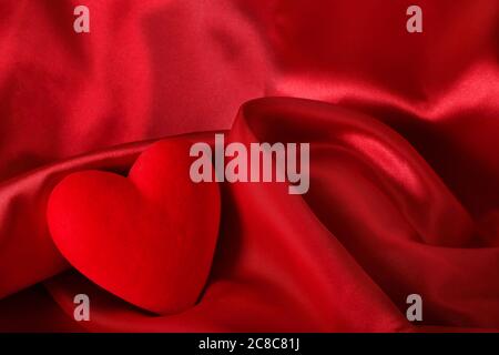 Red heart on satin fabric background Stock Photo - Alamy