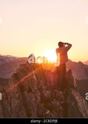 Man photographing sunset on the top of mountain Stock Photo - Alamy