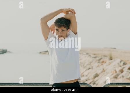 Man stretching while standing against clear sky Stock Photo - Alamy