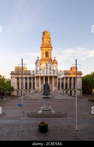 Light hitting the clock tower of Portsmouth Guildhall during sunrise ...