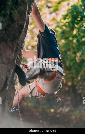 A rockclimber finding a foothold on the steep mountain he's climbing ...