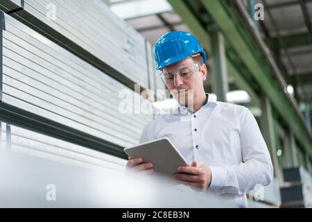 Businessman in hard hat holding blueprint Stock Photo - Alamy