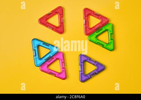 Top view of colorful magnetic building blocks on yellow background ...