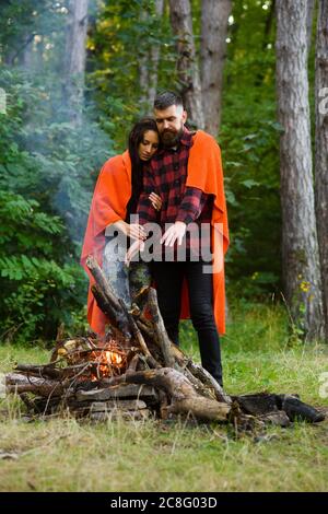 Man with woman hugs and warming up near bonfire Stock Photo - Alamy