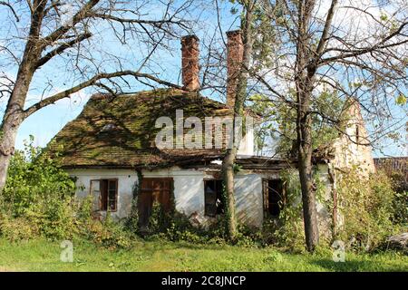 Abandoned small suburban family house ruins with large hole in middle ...