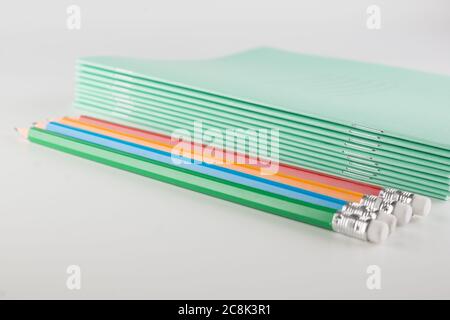 stack of thin student notebooks with colored pencils for school Stock ...