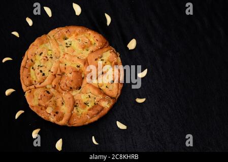Peeled Garlic with big round shape garlic bread isolated on black ...