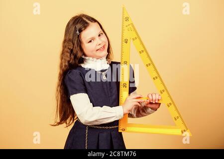 Back to school. School girl hold ruler measuring isolated on yellow ...