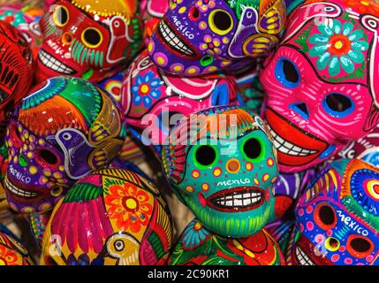 Painted ceramic skull with vibrant red gerbera daisy flowers. Dia de ...
