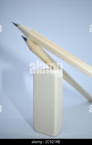 Vertical closeup shot of pencils and an eraser on a white background ...