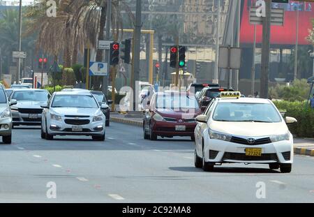 Kuwait City, Kuwait. 28th July, 2020. A taxi driver helps a passenger ...