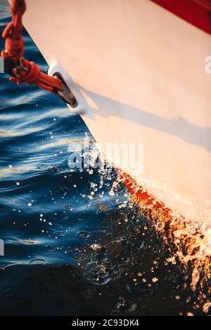 Bow of a sailboat cutting through water on journey over Caribbean Sea ...