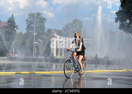 Vienna, Austria. 28th July, 2020. People cool off near a water spray on ...