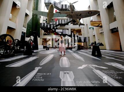 An Imperial War Museum member of staff stands on part of the surface of ...
