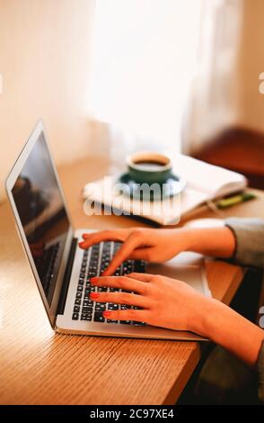 Faceless woman studying at a laptop. A female freelancer getting ready ...