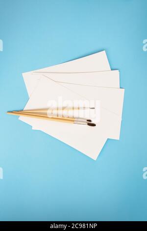 Different size watercolor brushes lie together with watercolor paper on ...
