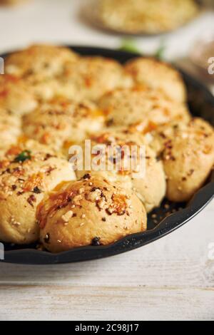 Freshly-made delicious cheese bubble pizza bread with ingredients and cheese on a white table ...