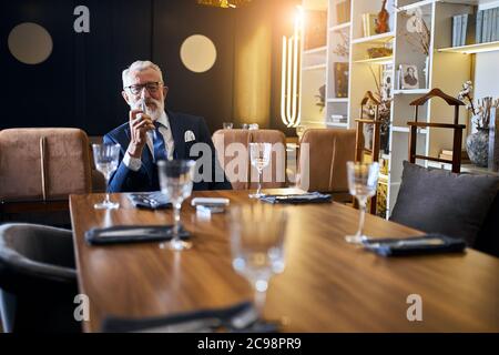 Elderly man vaping in closed public space. Smoking electronic cigarette ...
