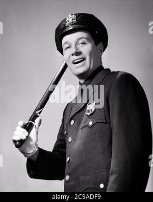 a friendly looking police officer smiles and stands next to her patrol ...