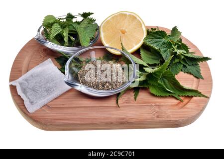 Fresh healthy nettle plant, lemon and dried herbs isolated on a white ...