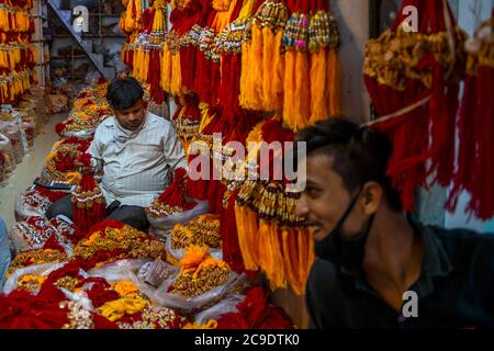 Bunches of rakhis for sale are hanged on a rope in front of a shop ...