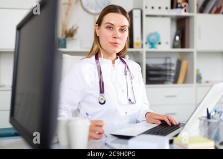 Smiling woman doctor working effectively in her office Stock Photo - Alamy