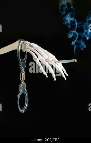 Skeleton hand holding burning cigarette Stock Photo - Alamy