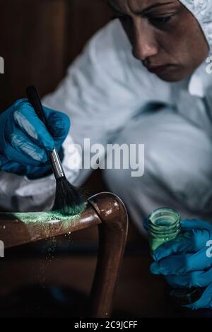 Crime scene. Forensics expert dusting for fingerprints at a crime scene ...