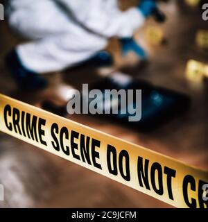 Forensic investigator collecting blood sample at crime scene ...