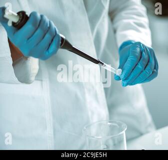 Microbiology. Hands of a microbiologist pipetting sample Stock Photo ...