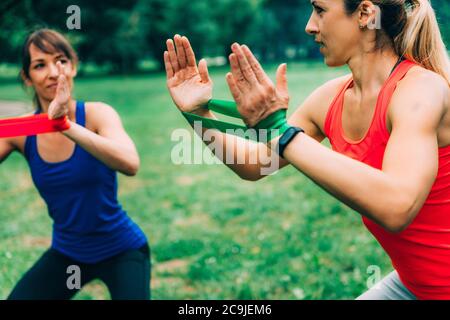 Women exercising with elastic band in the park Stock Photo - Alamy