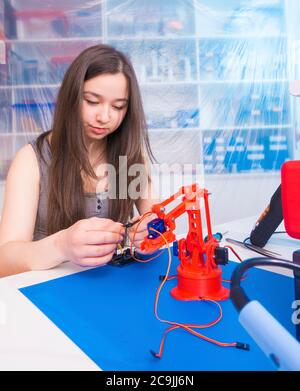 Girl working on robotic arm. Concept robotics, science, IT technologies ...