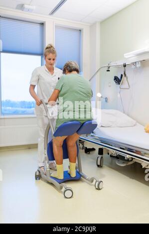 Geriatric hospital ward. Nurses helping a confused patient on the ...