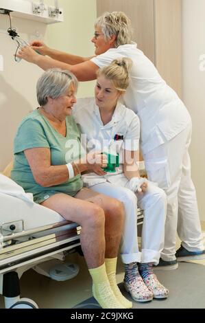 Geriatric hospital ward. Nurses helping a confused patient on the ...