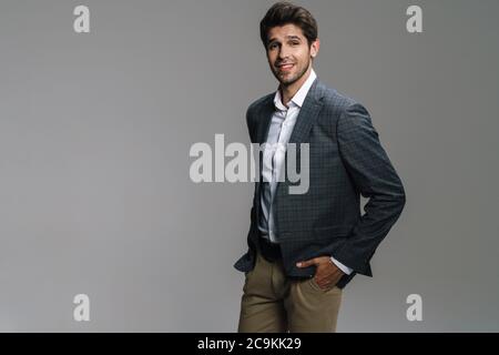 Photo of pleased businessman in jacket posing and smiling at camera ...