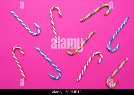 lot of multi-colored candy canes on a pink background, copy space Stock ...