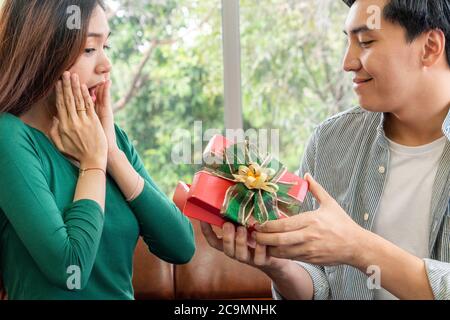 Happy couple giving gift present to celebrate anniversary. Marriage ...