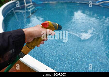 Garden Hose Pouring Water into a Swimming Pool Stock Photo - Alamy