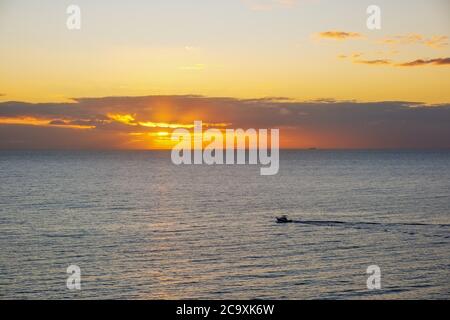 boat trail in water with sunset and cloudscape Stock Photo - Alamy