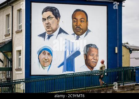 A man walks past the Bogside mural in Derry City of John Hume, Martin ...